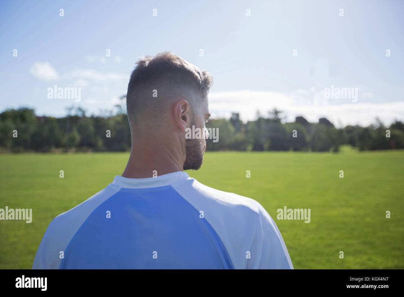Rear view of football player standing in the ground on a sunny day ...