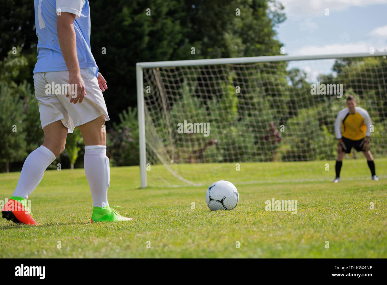 Soccer player is ready to kick ball from penalty spot in the ground ...