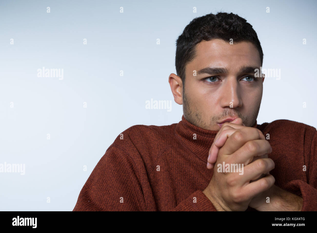 Close-up of man in sweater shivering against white background Stock ...