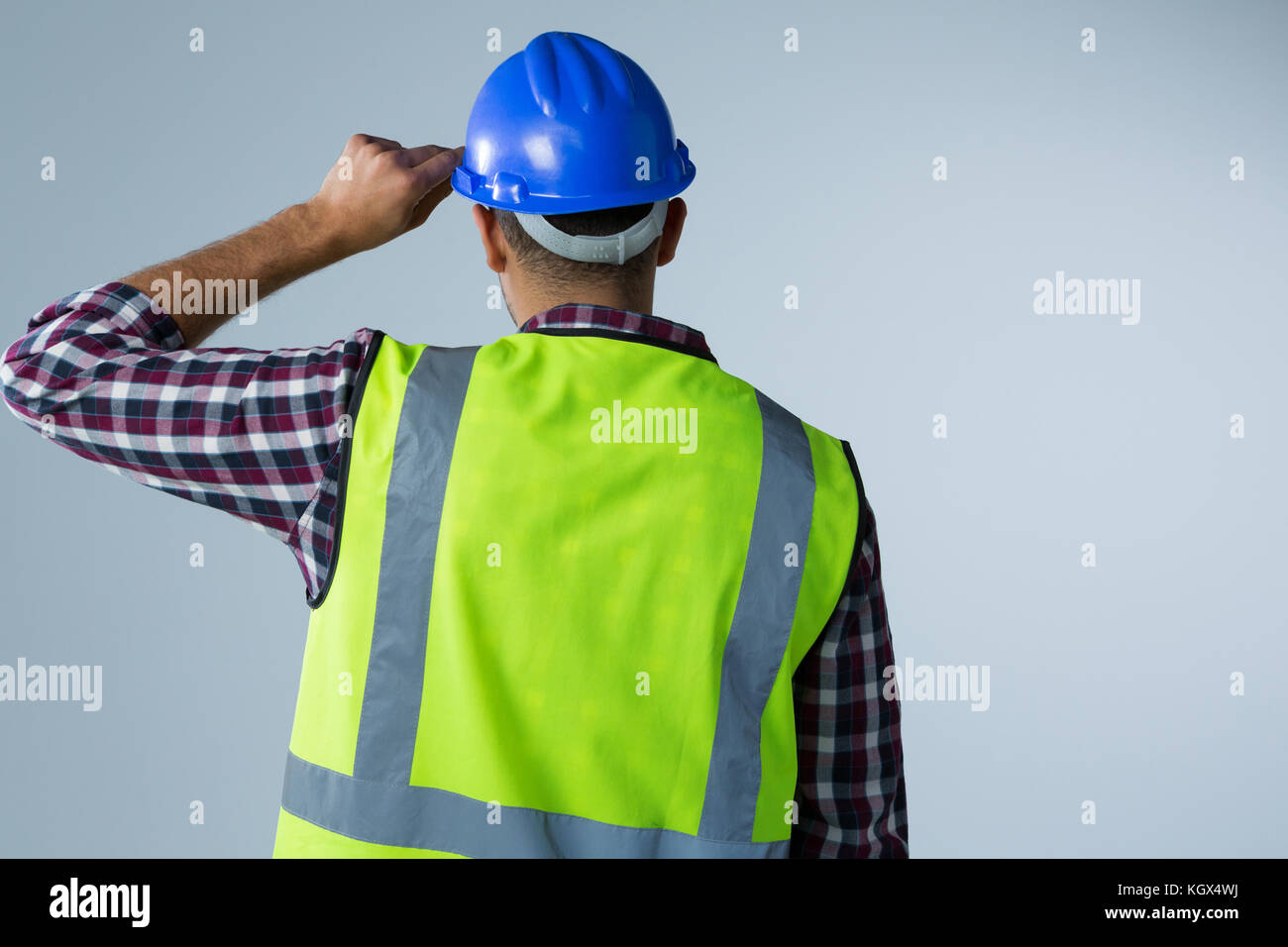 Rear view of male architect standing against white background Stock ...
