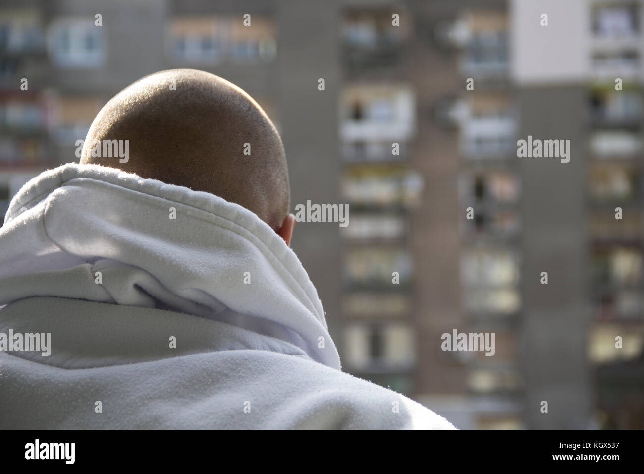 A Young Man From The Balcony Watching The Building Stock Photo - Alamy
