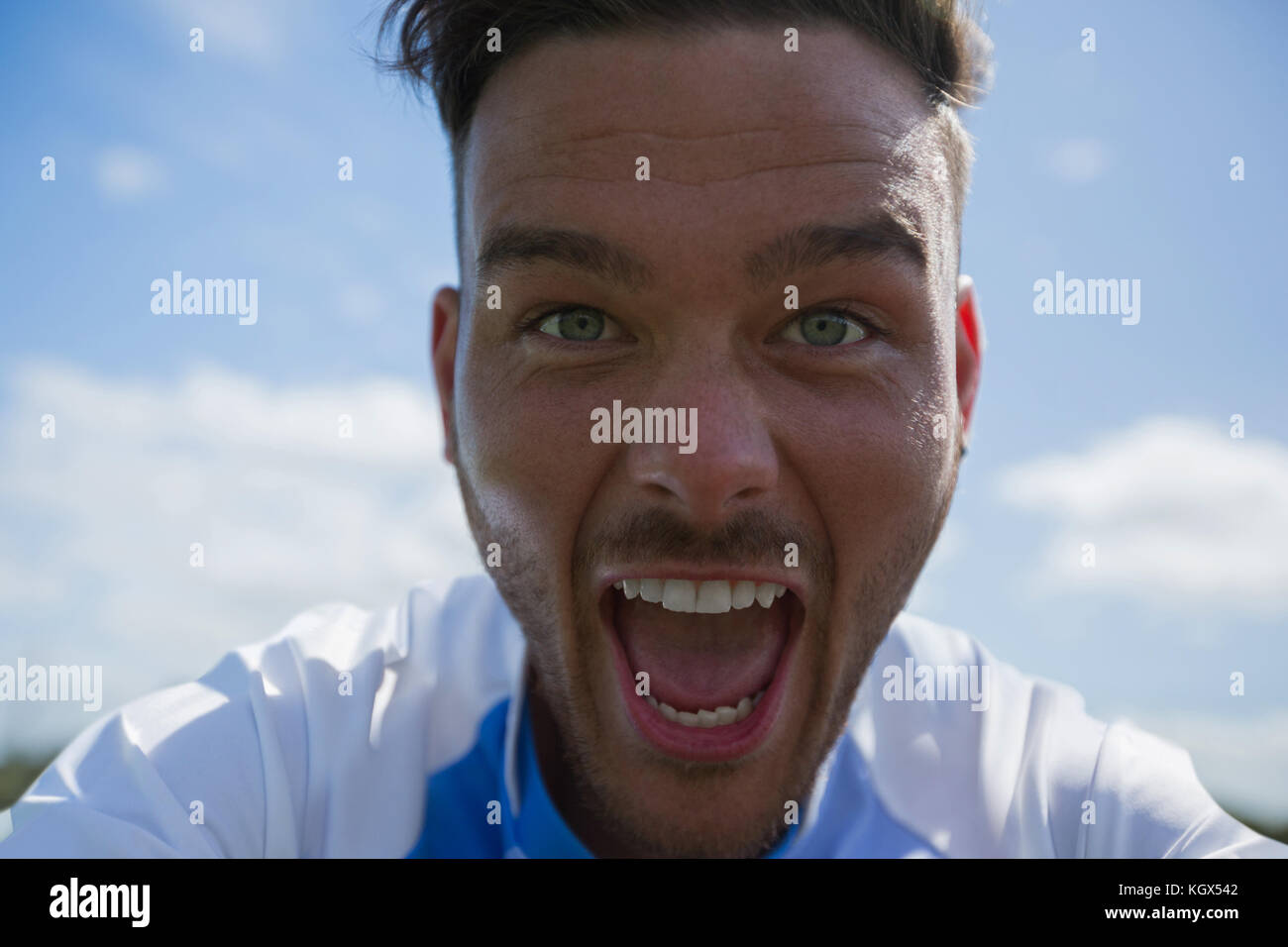 Excited football player looking at camera on a sunny day Stock Photo ...