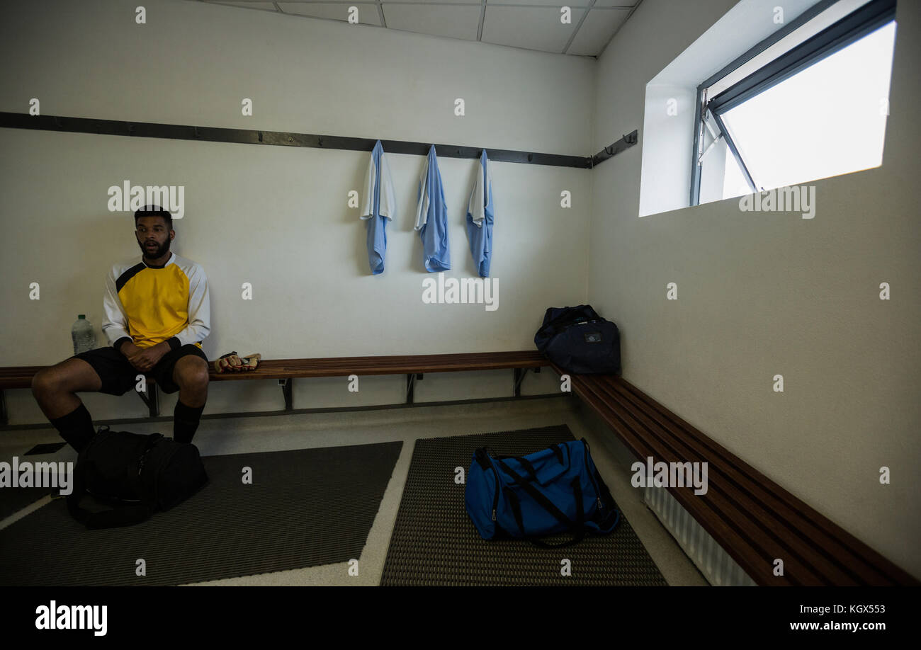 Thoughtful football player relaxing in changing room Stock Photo - Alamy