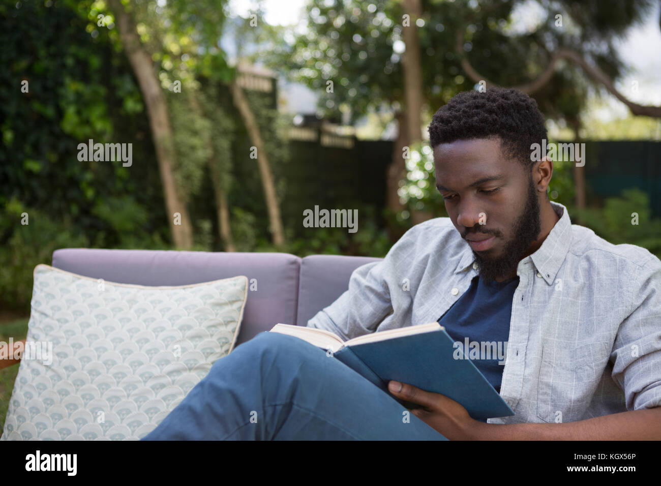 Man reading a novel in garden Stock Photo - Alamy