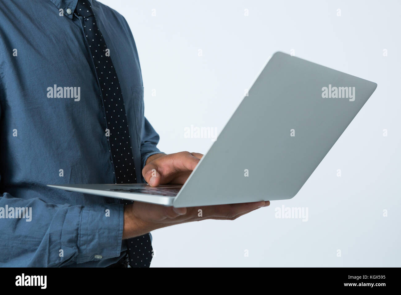 Mid section of executive using laptop against white background Stock ...