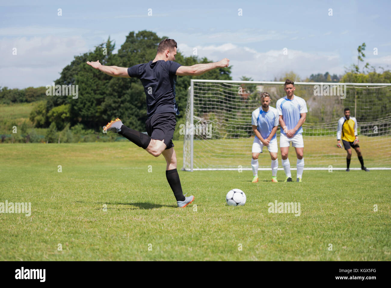 Football player taking a penalty shot in the ground Stock Photo - Alamy