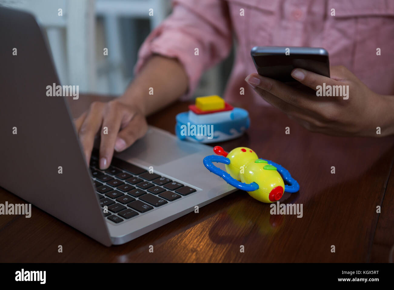 Mid section of woman using laptop and mobile phone at home Stock Photo ...