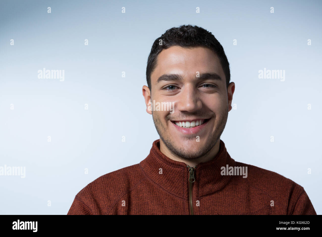 Smiling man looking at camera against white background Stock Photo - Alamy