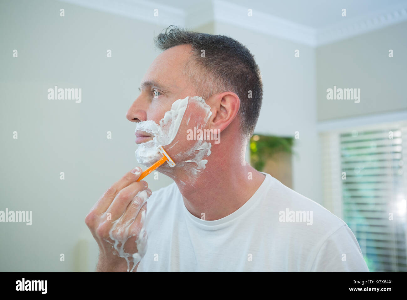 Man shaving his beard with razor in bathroom Stock Photo - Alamy