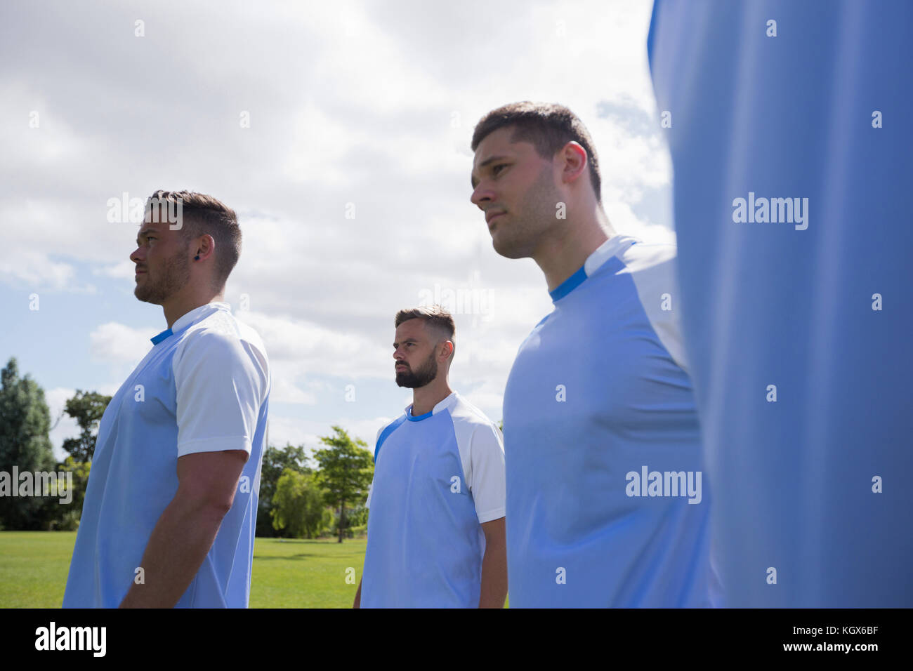 Football players standing in ready position on ground Stock Photo - Alamy