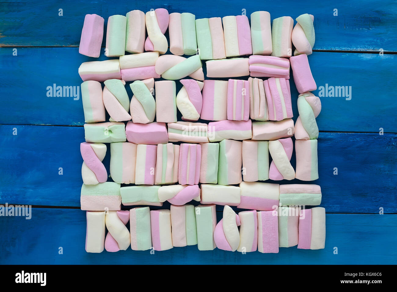 marshmallow candies in a square shape on a blue wooden background ...