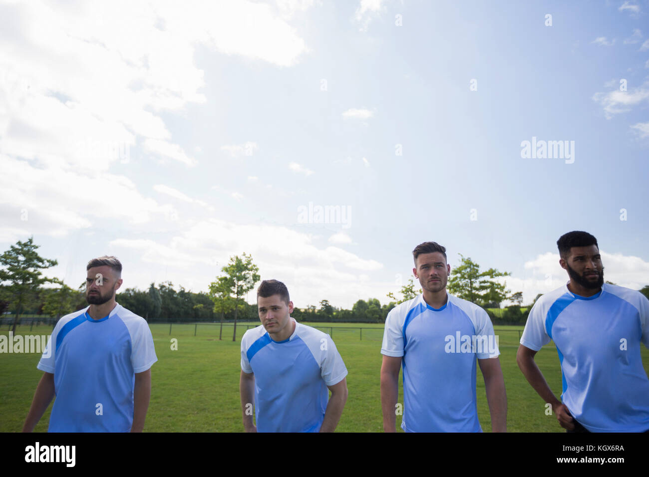 Football players standing in ready position on ground Stock Photo - Alamy
