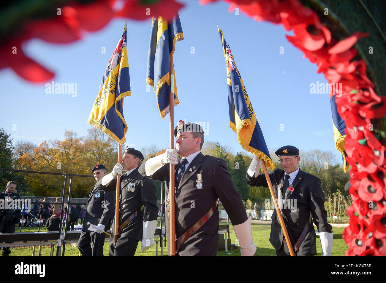 Royal British Legion standard bearers march past a wreath of poppies in ...