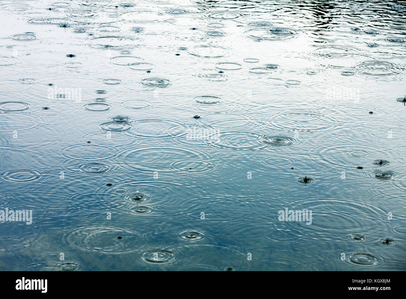 Raindrops at a water surface Stock Photo - Alamy