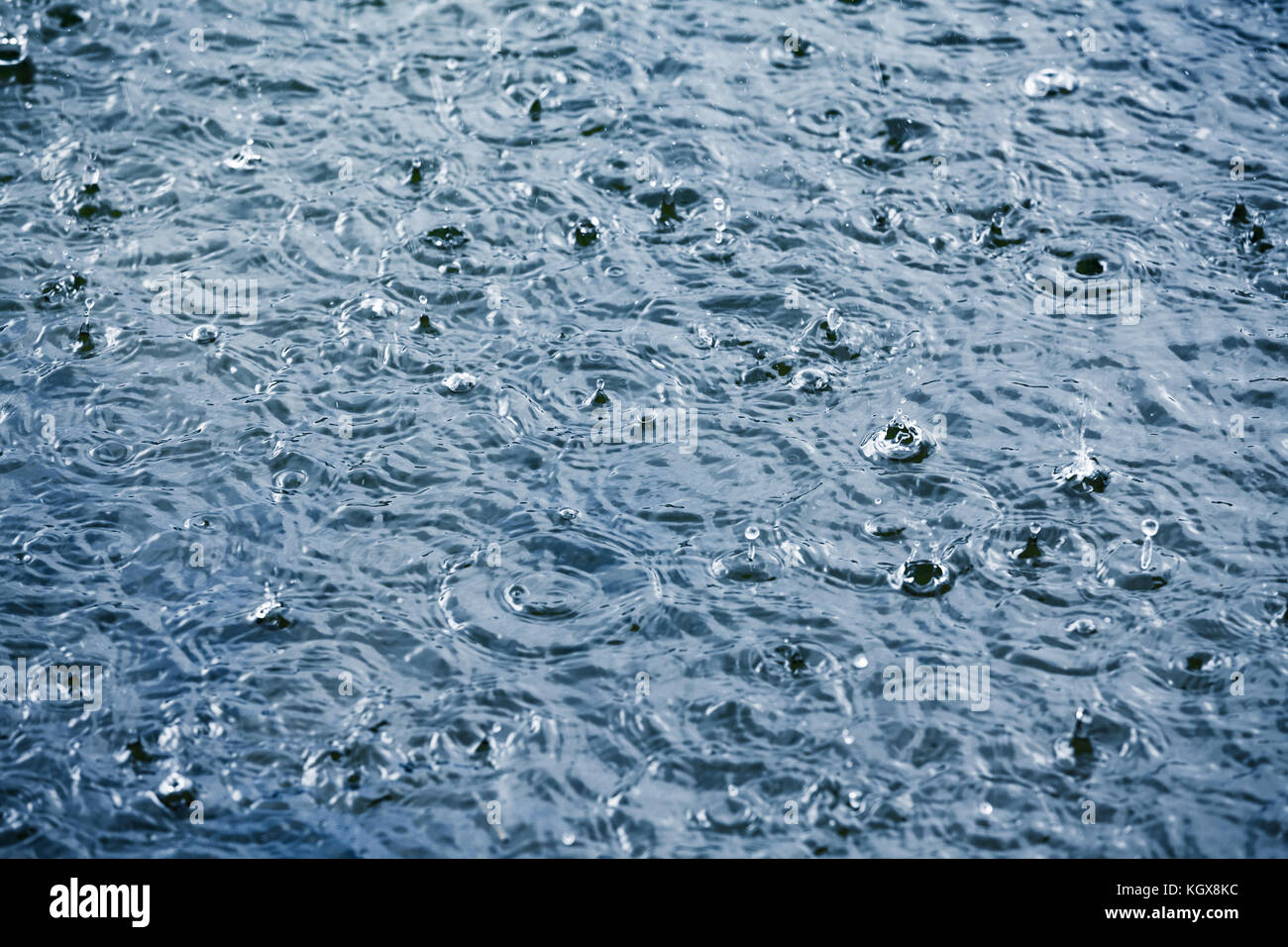 Raindrops on a water surface - a heavy rainfall stormy weather ...