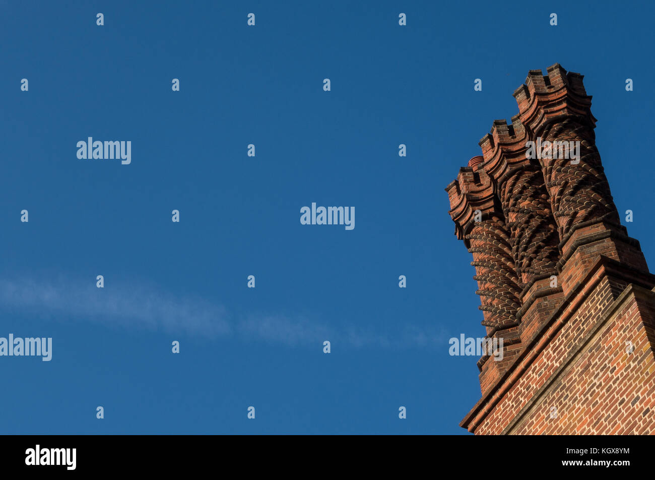 Close-up detail of ornamental red brick chimneys and chimney pots with ...