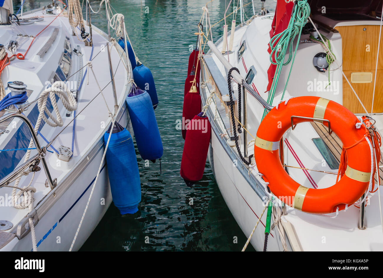 detail of two boats anchored with the typical colored fenders and the ...