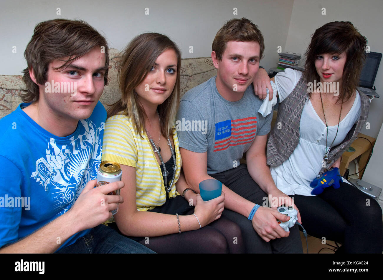 Four students sharing a house, sitting together on a sofa Stock Photo ...
