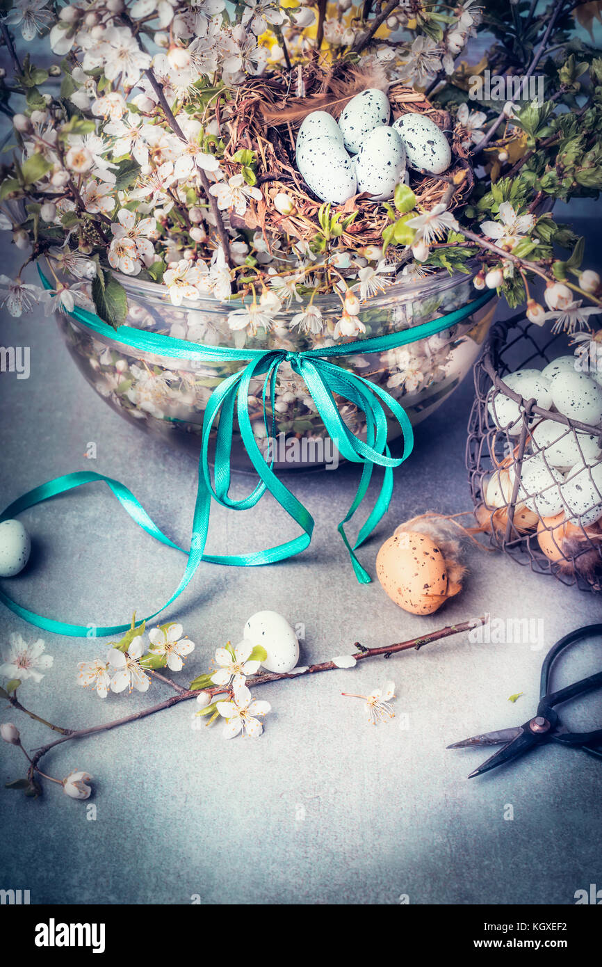 Easter decoration making with cherry branches blossom, eggs and shear ...