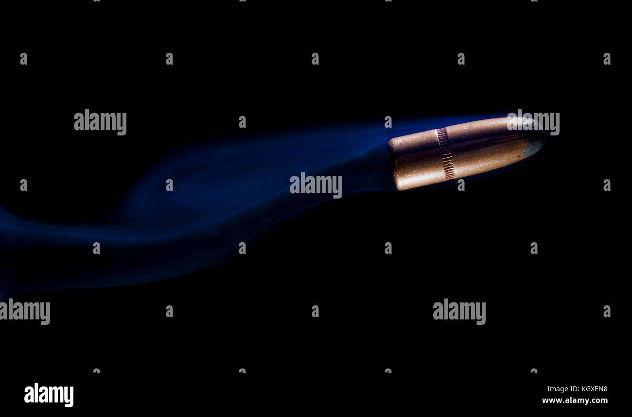 Bullet with smoke behind with a black background Stock Photo - Alamy