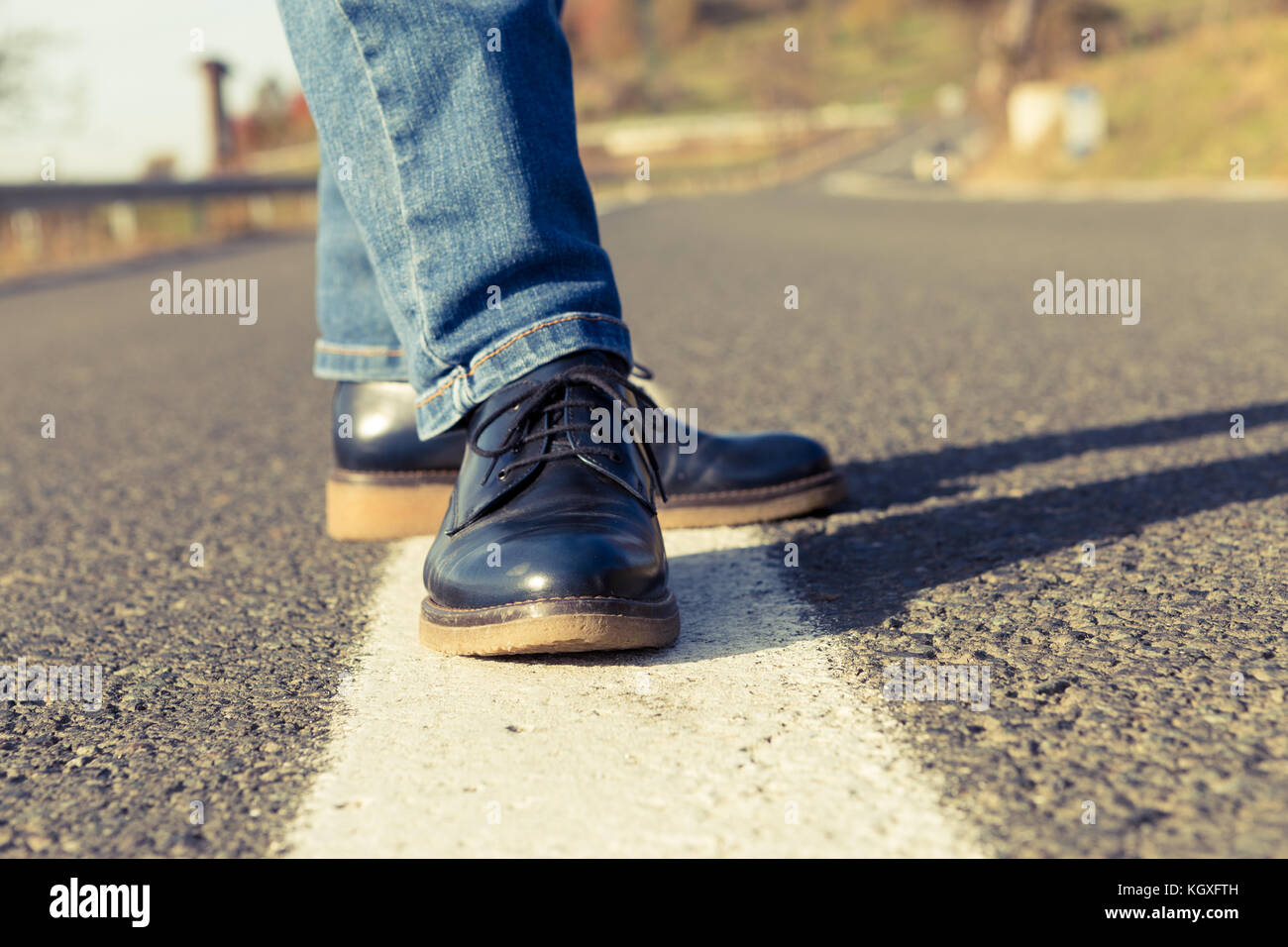Closeup of woman autumn shoes in the middle of the road on a sunny day ...