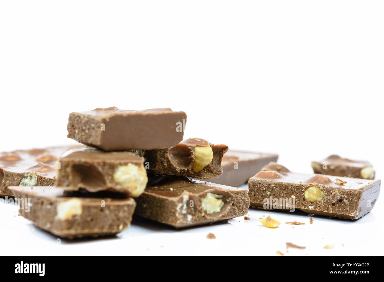 Stack of chocolate pieces with nuts in close-up and isolated on white ...