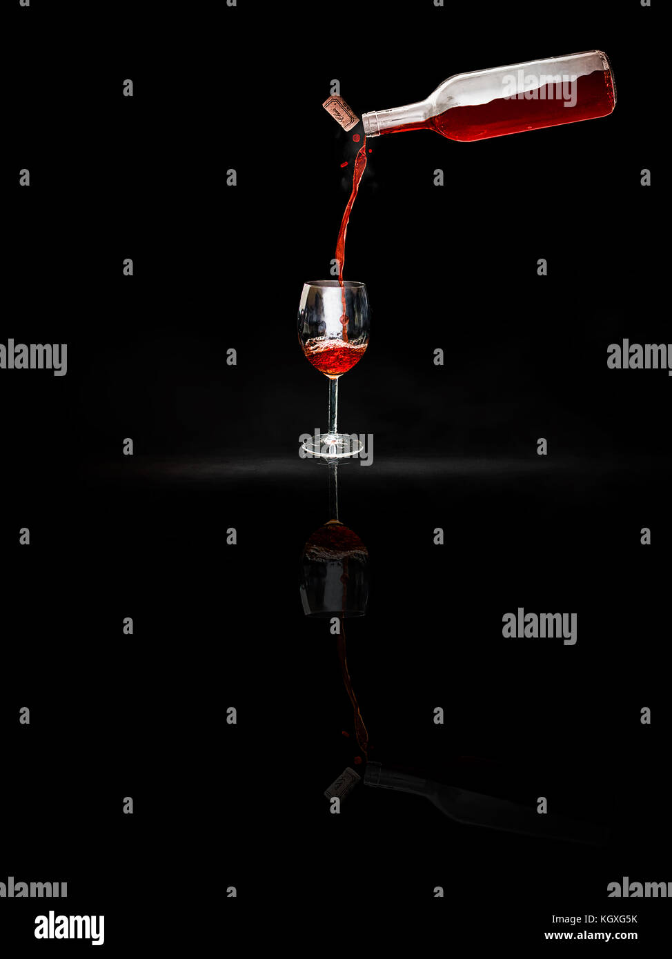 a pristine bottle of red wine floating and pouring into a wine glass ...