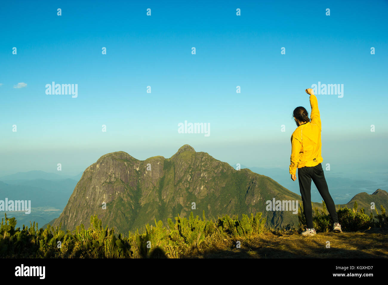 Man celebrating success on top of a mountain Stock Photo - Alamy