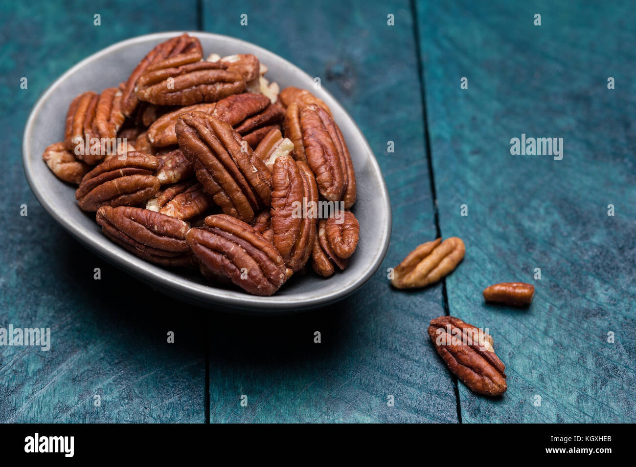 Pecans on petrol-colored wood in shell Stock Photo - Alamy