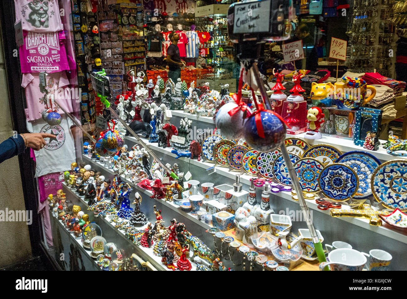 Woman's finger pointing to trinkets and souvenirs in a shop window ...