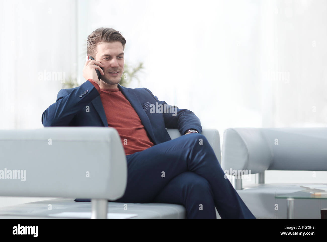 businessman talking on mobile phone sitting in a chair. the photo has a ...