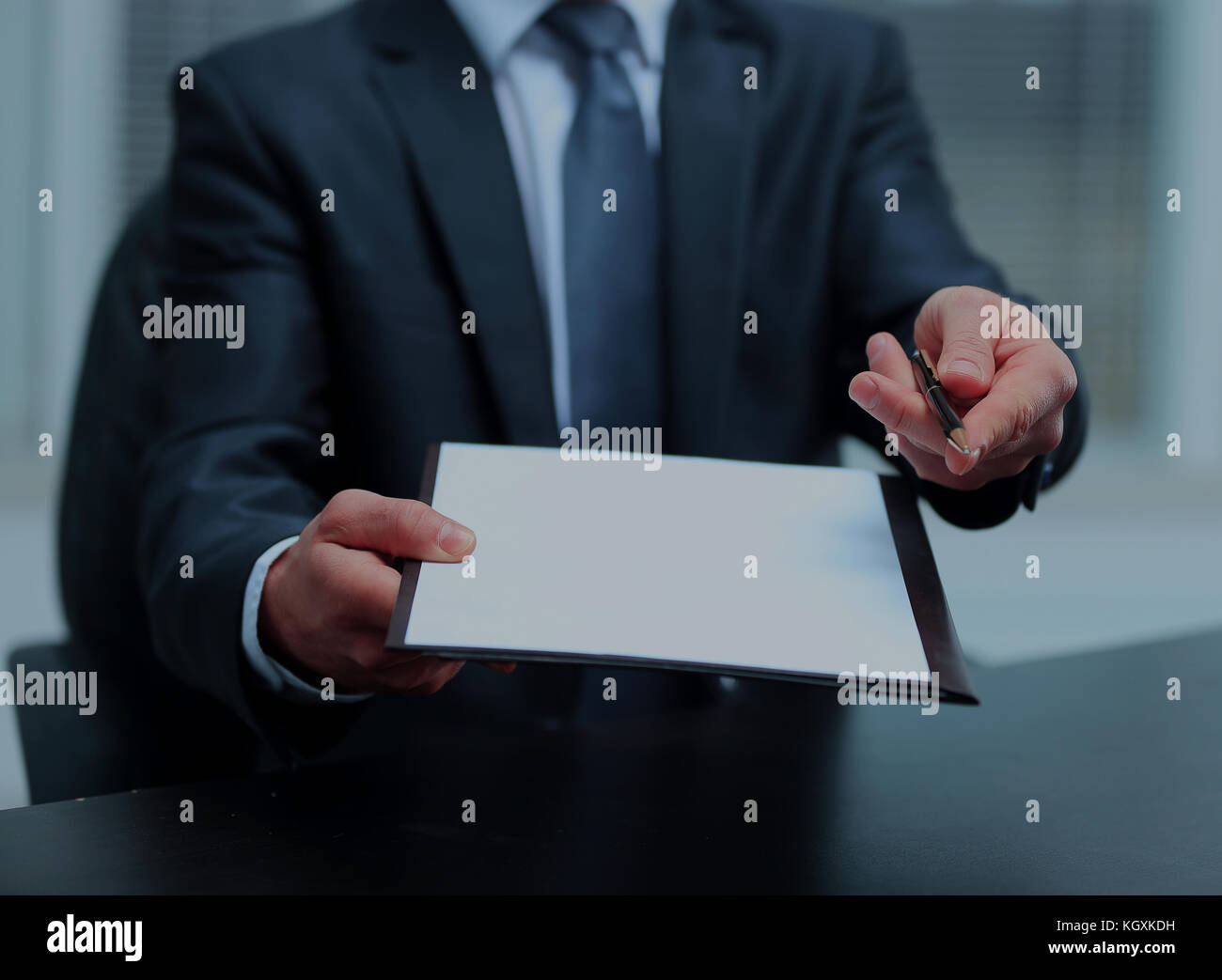 Businessman giving pen for your signature on clipboard Stock Photo - Alamy