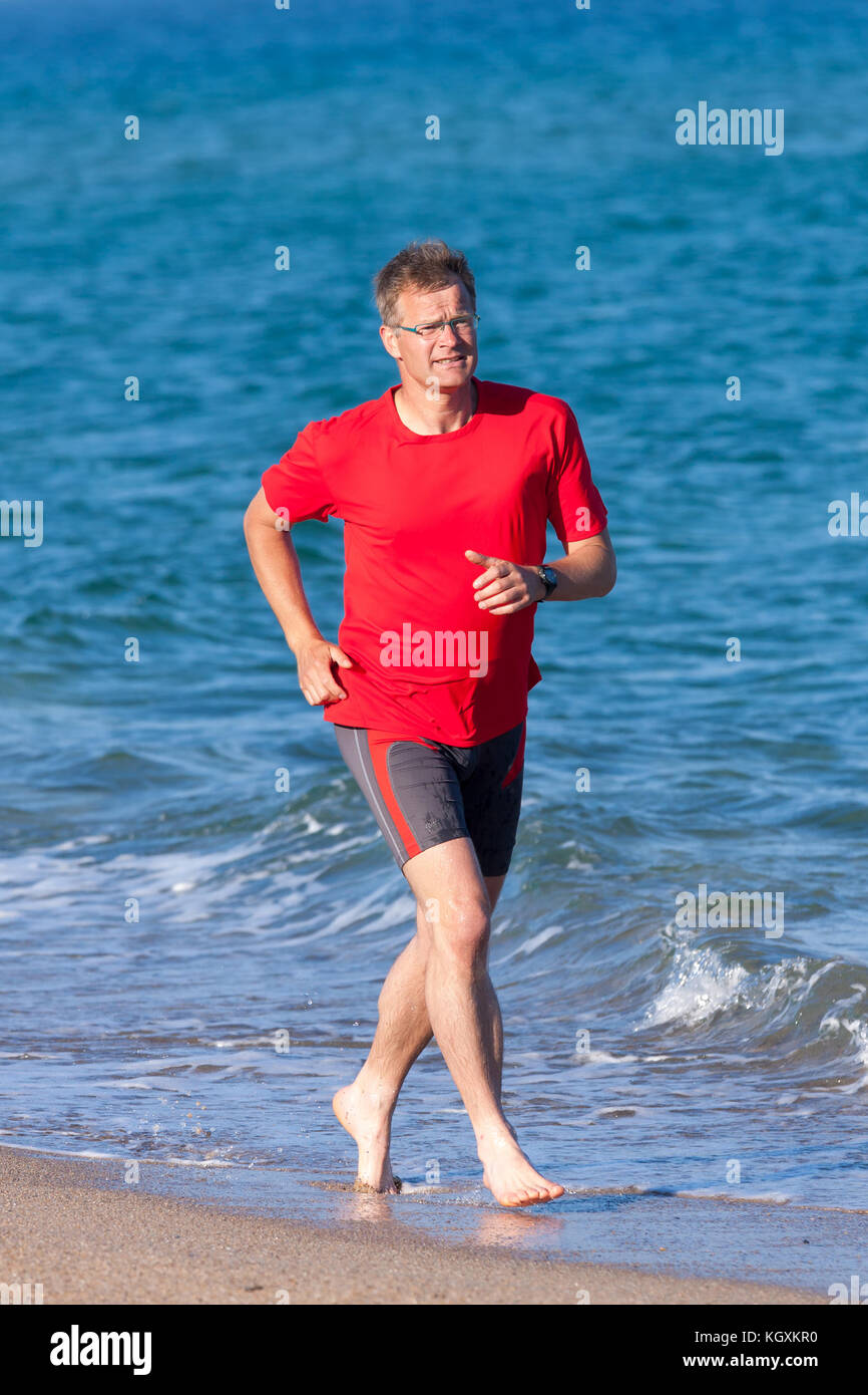 Young man running on the beach in Costa Brava, Spain Stock Photo - Alamy