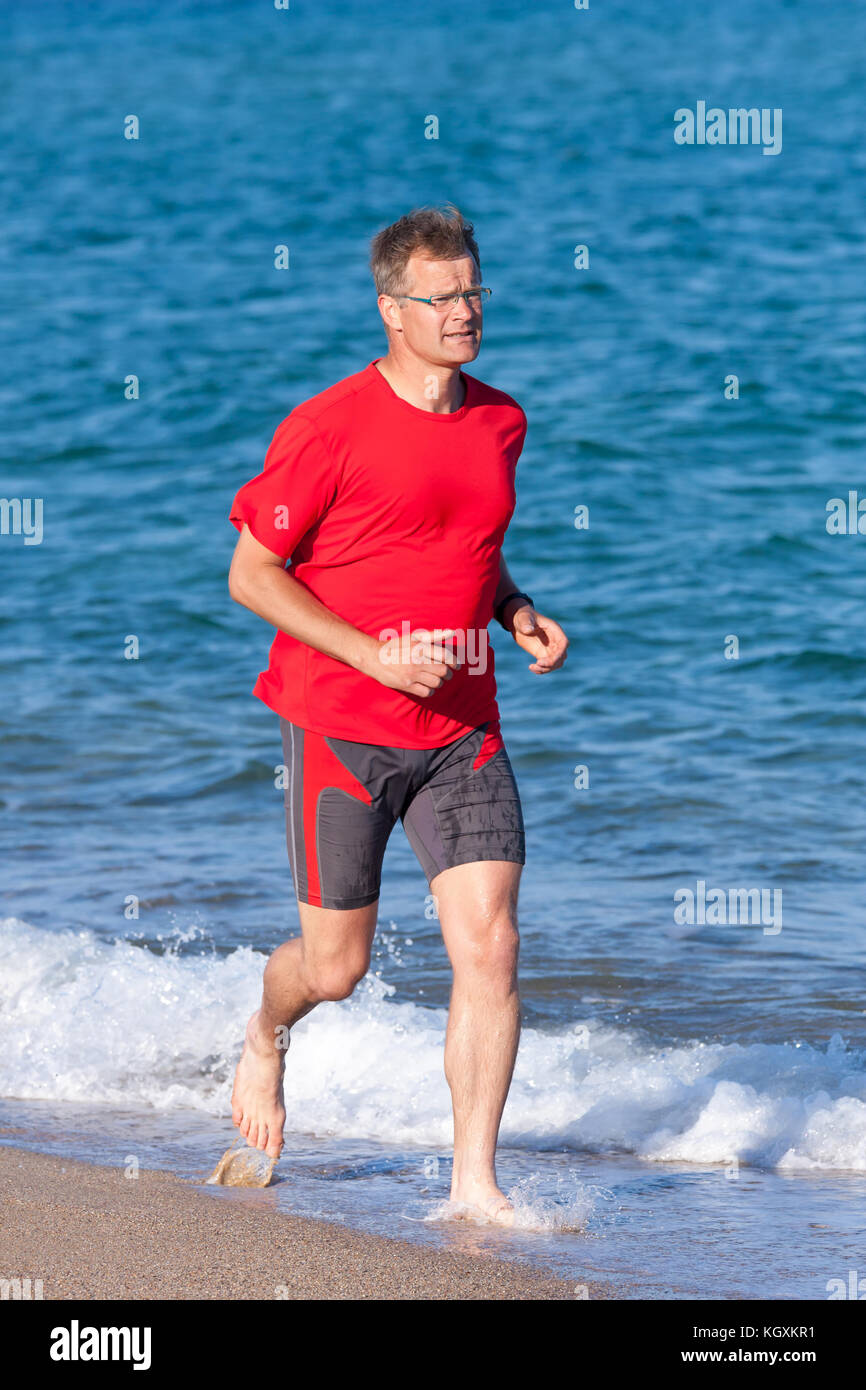 Young man running on the beach in Costa Brava, Spain Stock Photo - Alamy