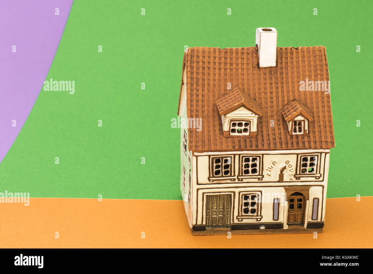 Little toy house on orange green and violet backgrounds Stock Photo - Alamy