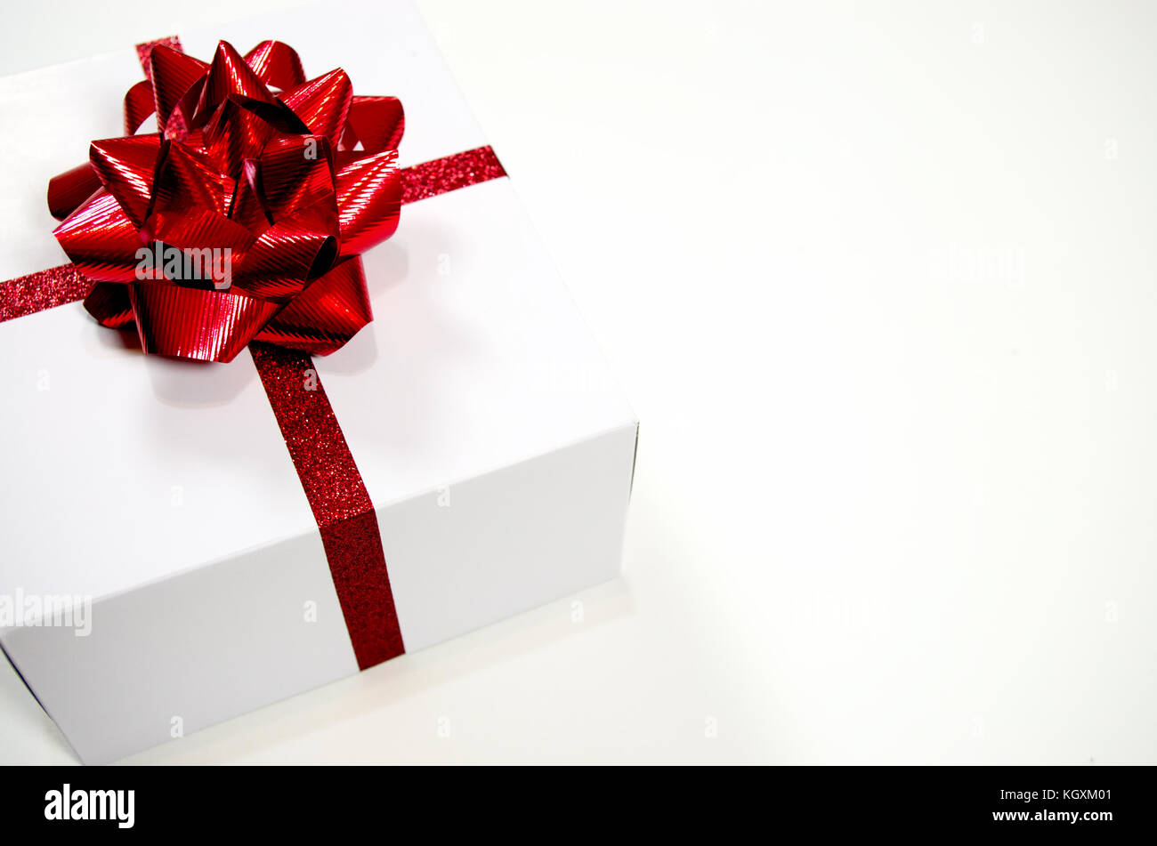 Single Christmas present with red bow on a white background Stock Photo ...