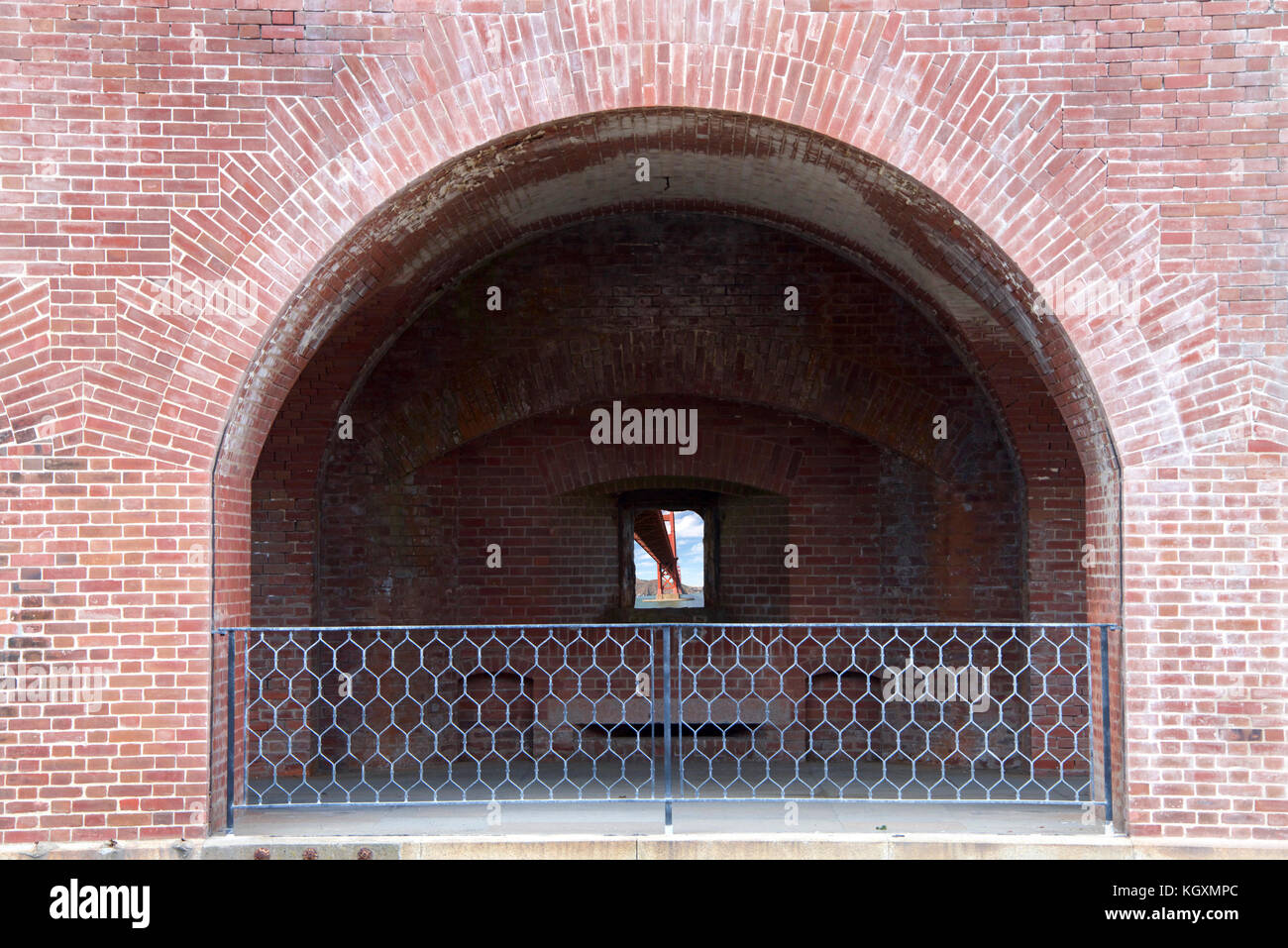 Old fort brick walkway, decrepit falling apart, stained. window at end ...