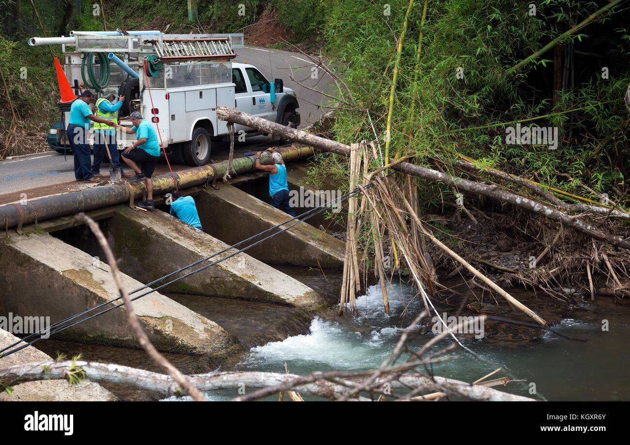 Puerto Rican Aqueduct and Sewer Authority workers fix a damaged ...