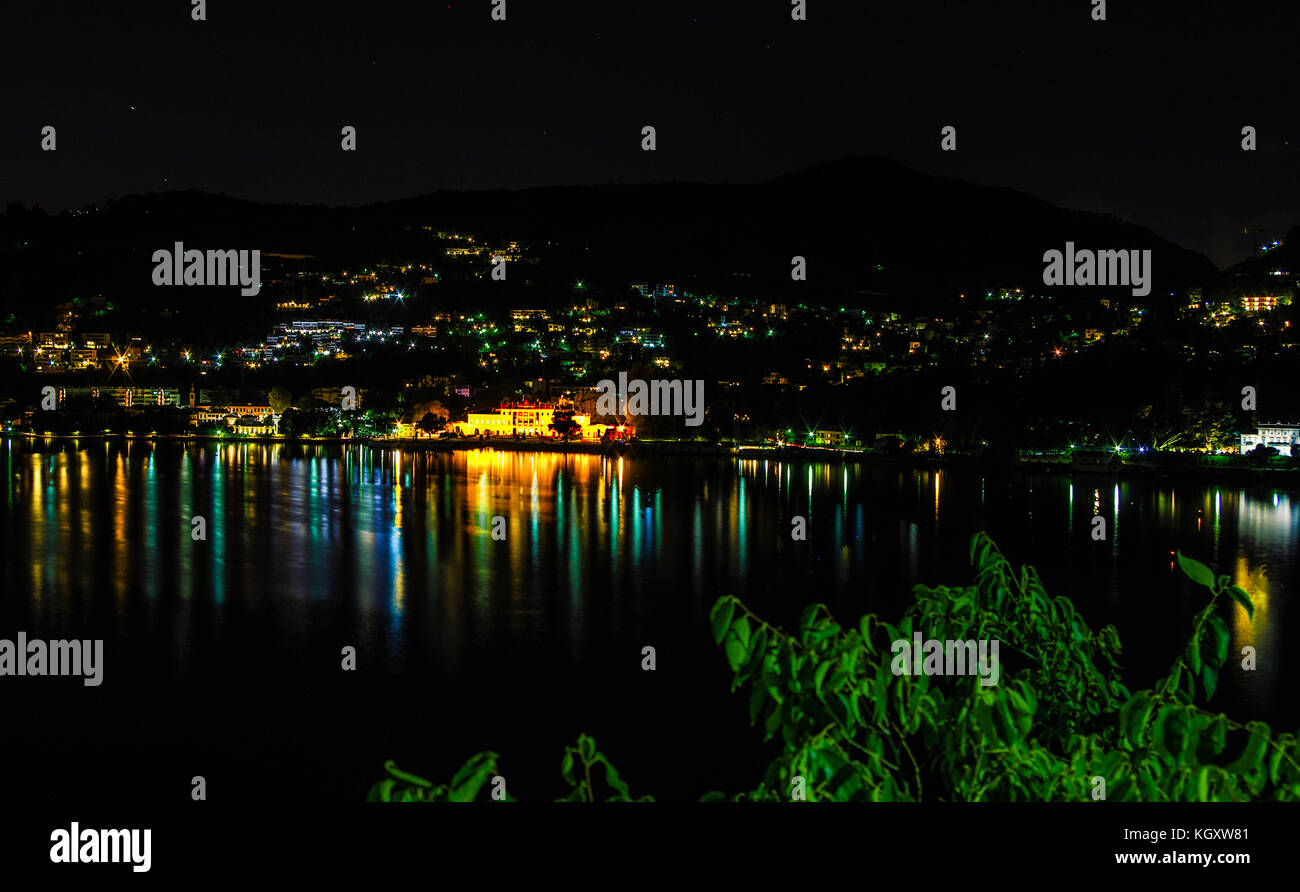 the shore of the lake illuminated by colored lights reflecting on the ...
