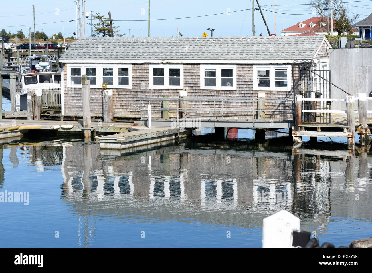 Harbormaster's shack with it's windows reflecting into the water in ...