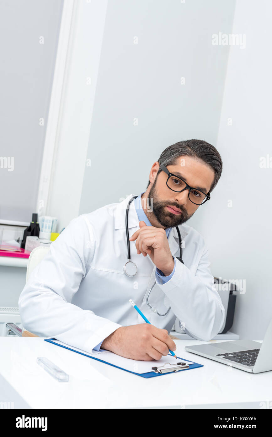 doctor writing in clipboard Stock Photo - Alamy