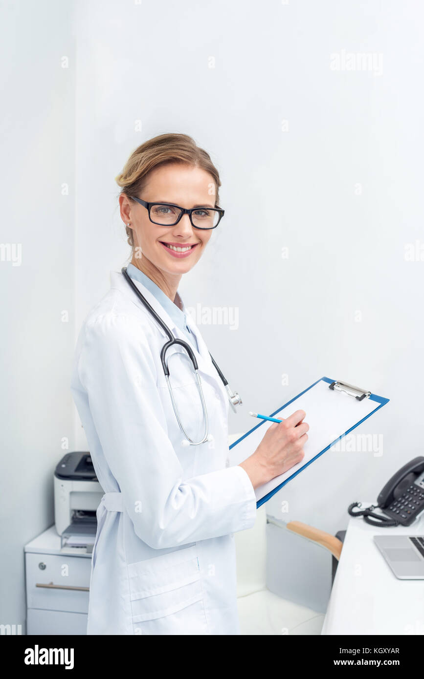 female doctor writing in clipboard Stock Photo - Alamy
