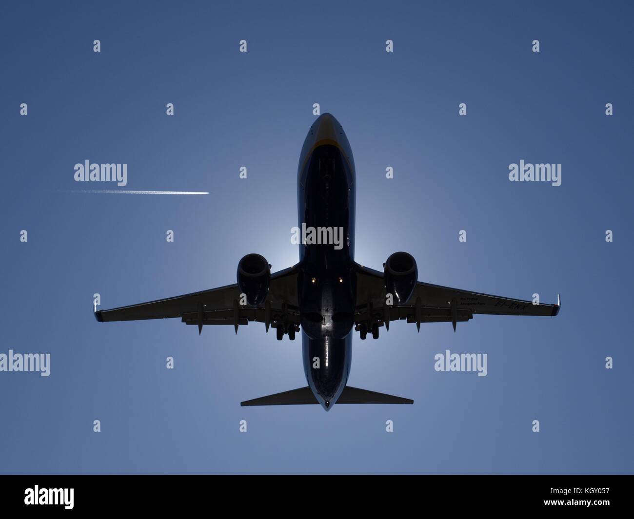 Landing airplane shot from below with sun background Stock Photo - Alamy