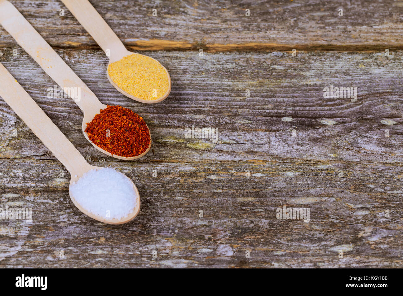 Different spices in wooden spoons on a wooden table ground spices for ...