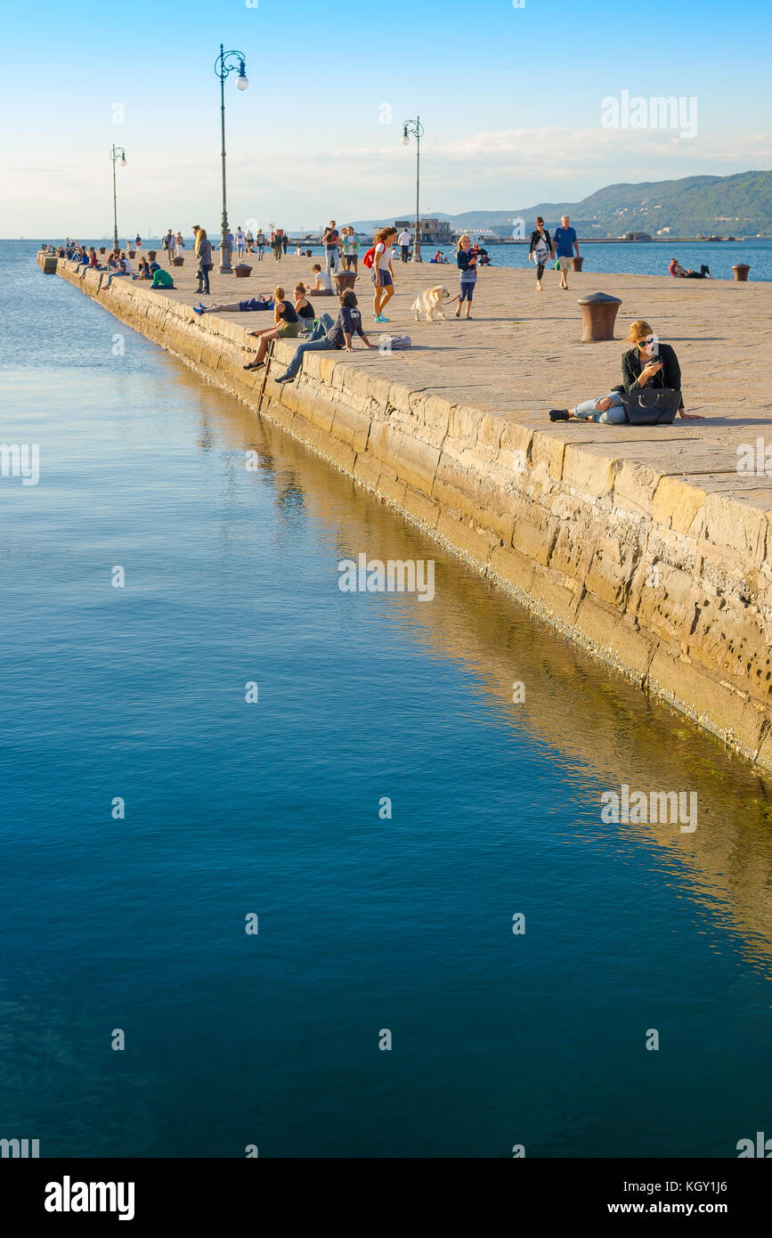 People sitting on long jetty and waterfront hi-res stock photography ...
