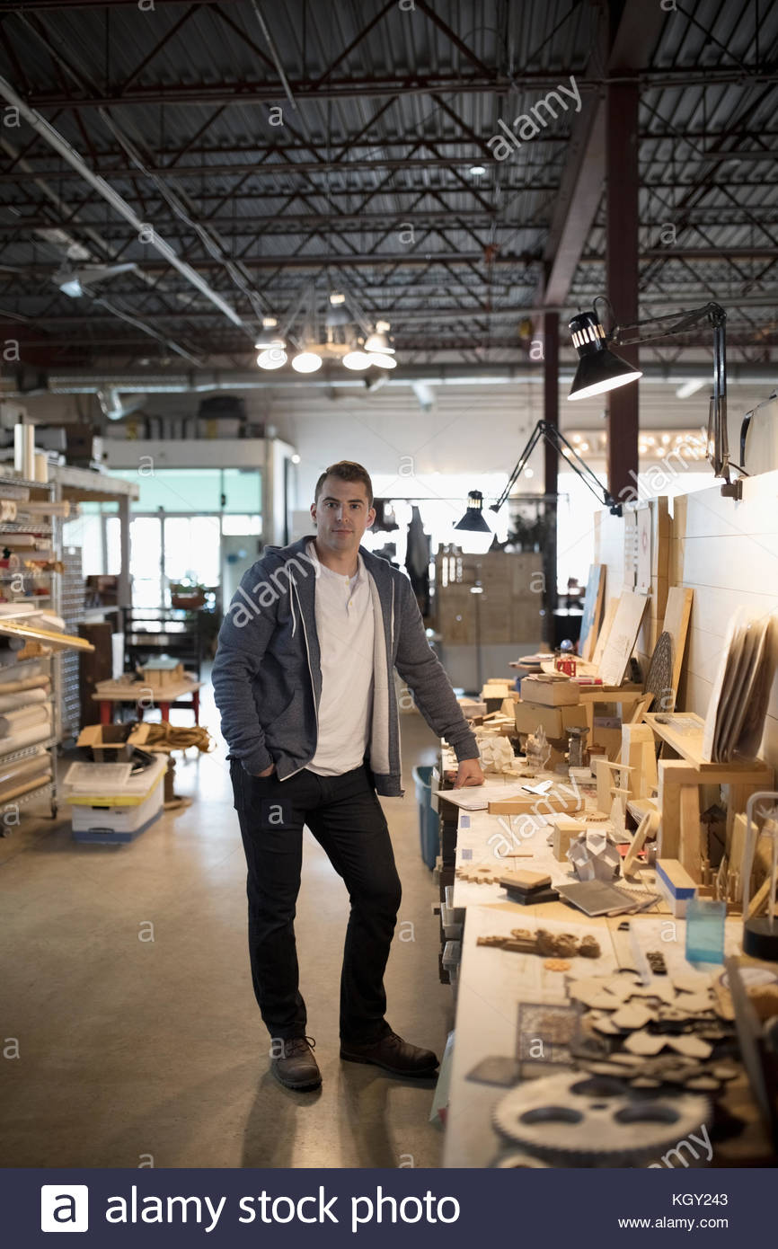 Portrait confident male craftsman working with laser cut wood pieces in ...