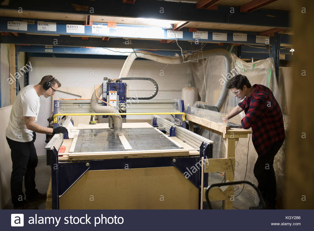 Male machinists using CNC cutter in workshop Stock Photo - Alamy