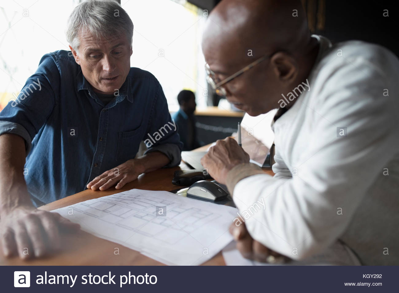 Senior male engineers reviewing blueprints in meeting Stock Photo - Alamy