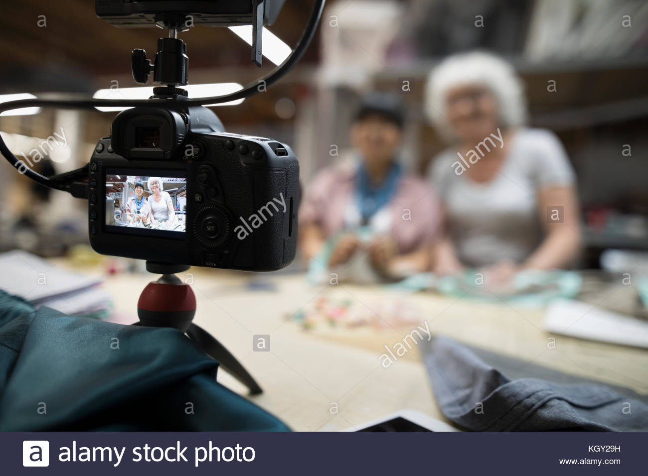 Smiling female fashion designers vlogging with digital camera in ...