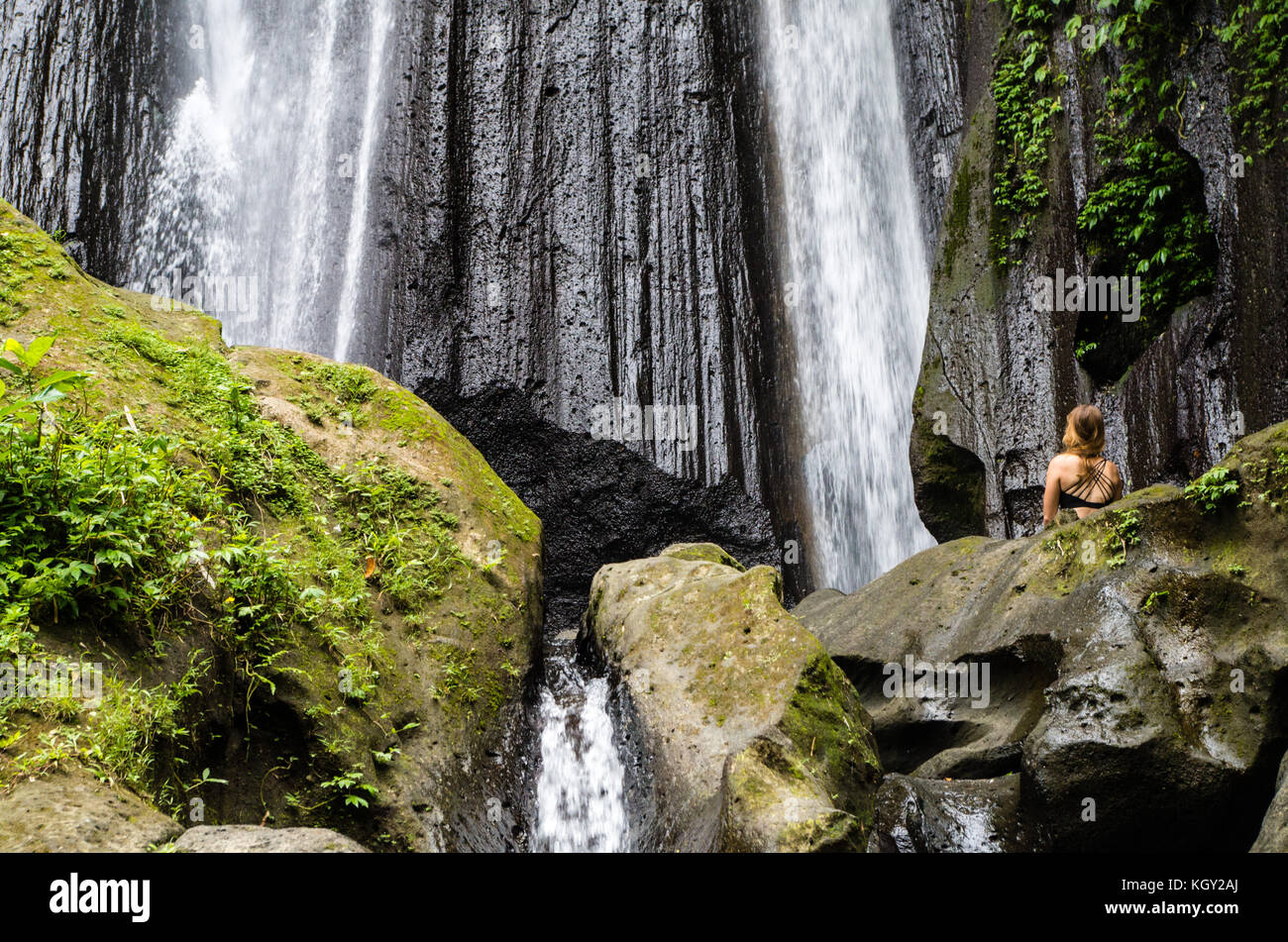 Woman meditating in front of kuning waterfall, Bali, Indonesia Stock ...